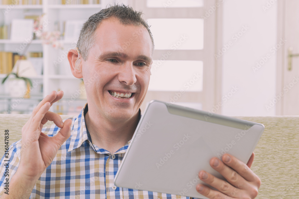 Deaf man using sign language on the tablet Stock Photo | Adobe Stock