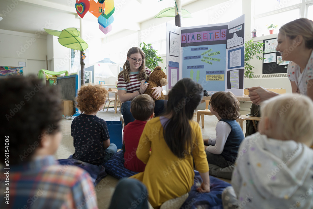 Preschool students watching tween girl giving diabetes presentation in ...