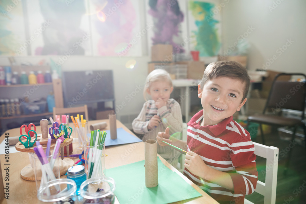 Portrait smiling boy making art and craft project in classroom Stock ...