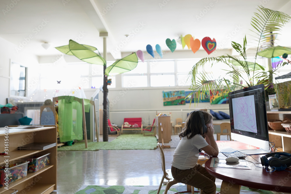 Preschool girl student drawing at computer in classroom Stock Photo ...