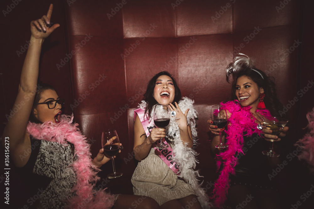 Playful, exuberant young female millennial friends drinking ...