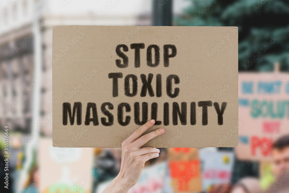 The phrase " Stop toxic masculinity " on a banner in men's hand. Human ...