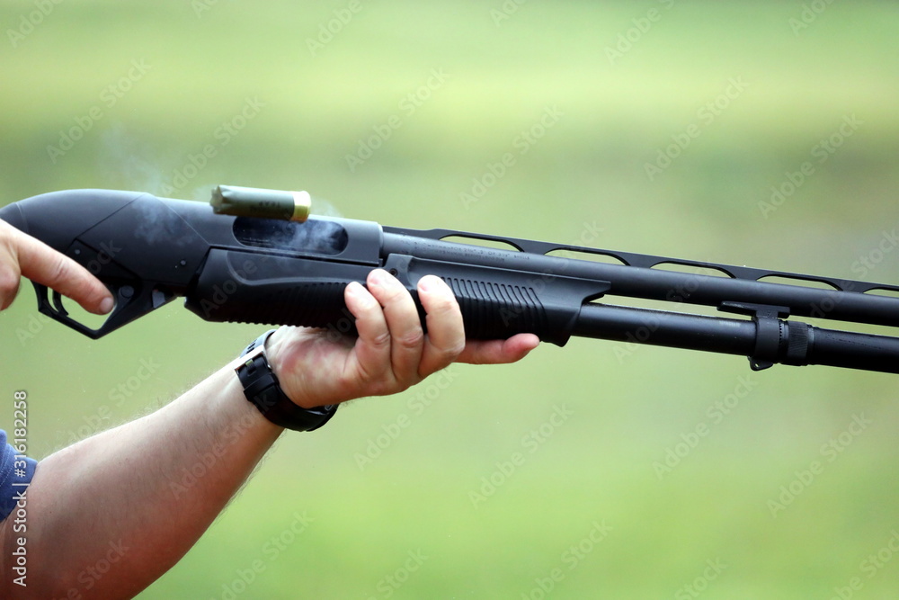 Shotgun with ejecting cartridge Stock Photo | Adobe Stock
