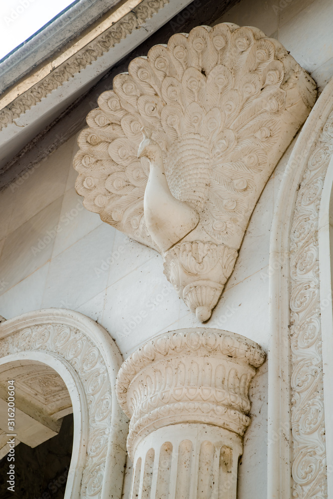 detail of a decorative carved marble column in an Indian temple under ...