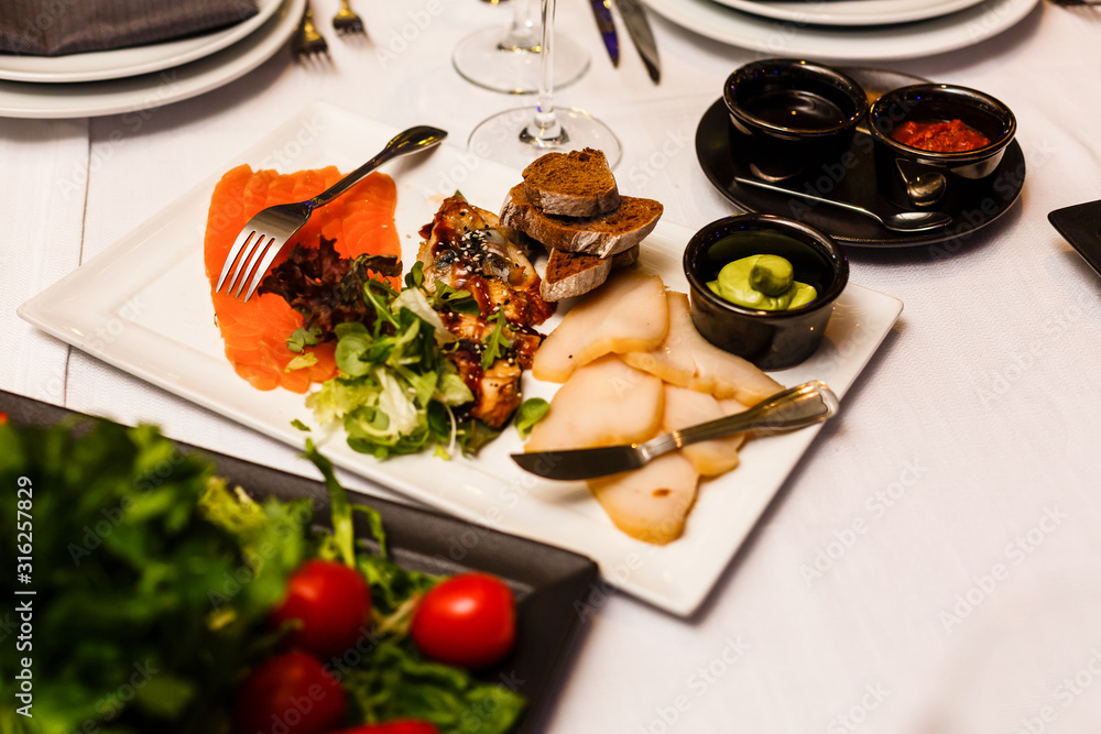 Fish platter in restaurant. Slices of salmon fish, smoked eel, white ...