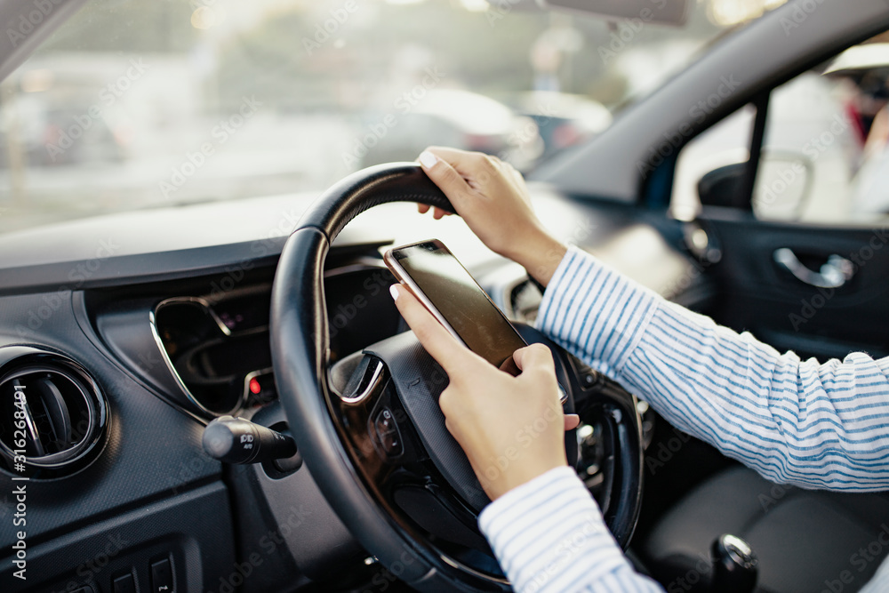 Young woman holding blank screen cell phone, driving car. Female ...