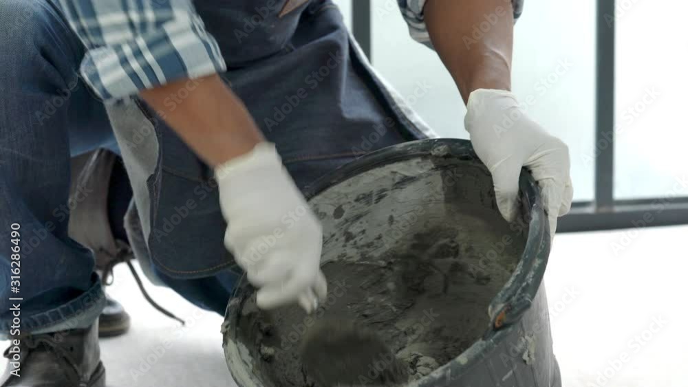 4K Senior man worker working at construction site using trowel mixing ...