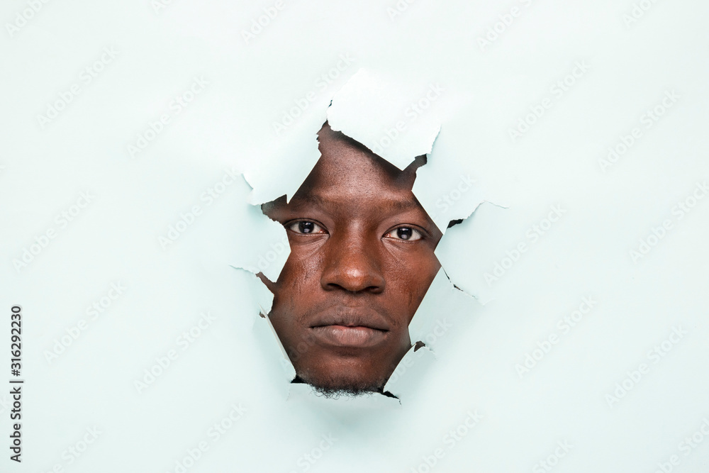 young black man with head through a cardboard paper with a straight ...