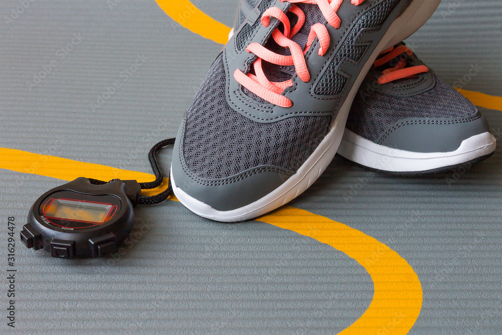 Sports running shoes and a stopwatch for sports lying on a rubber ...