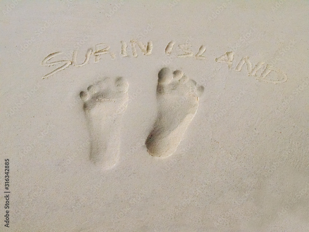 view of foot print and Surin island Text on white sand background ...