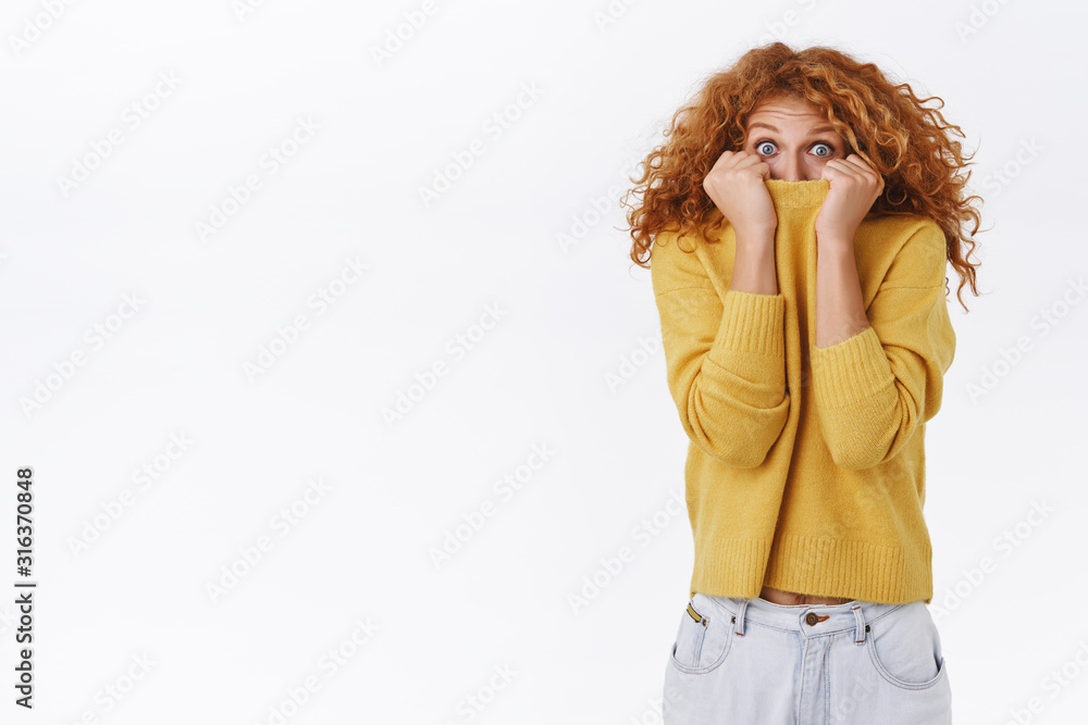 Scared, silly cute timid girl, hiding her face in sweater collar, pull ...