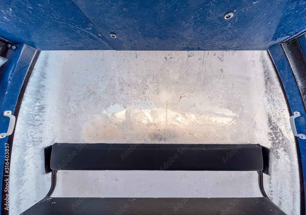 Interior of a cable car cabin in the mountains with padded bench and ...