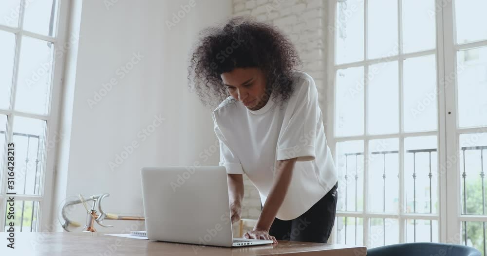 Focused young african american businesswoman typing email answer to ...