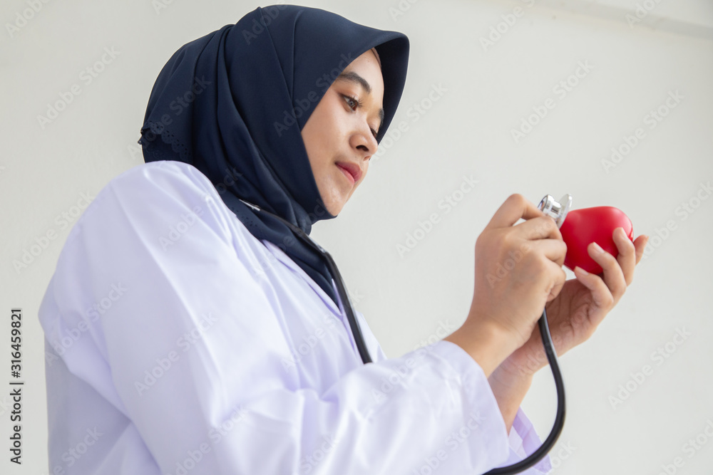 Muslim Female doctor with the stethoscope holding heart white ...