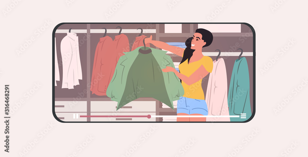 fashion stylist holding jacket in changing room wardrobe with different ...