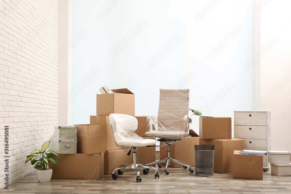 Moving boxes and stuff near white brick wall in room Stock Photo ...
