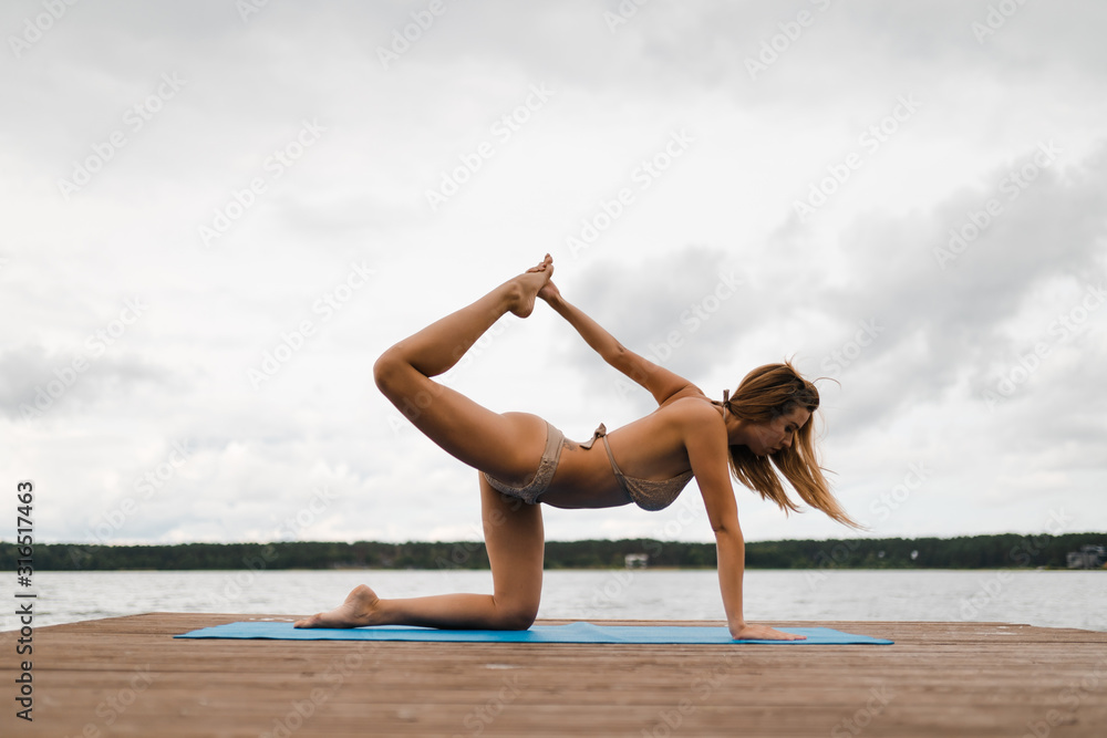 Fit Slim Woman Practicing Yoga Exercises Wearing Mini Swimsuit Bikini
