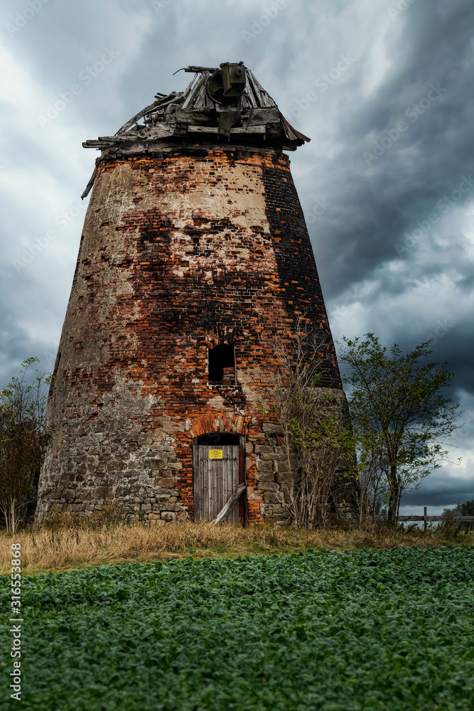 Alte verlassene Mühlenruine zwischen Wiesen, Bäumen und Sträuchern kurz ...