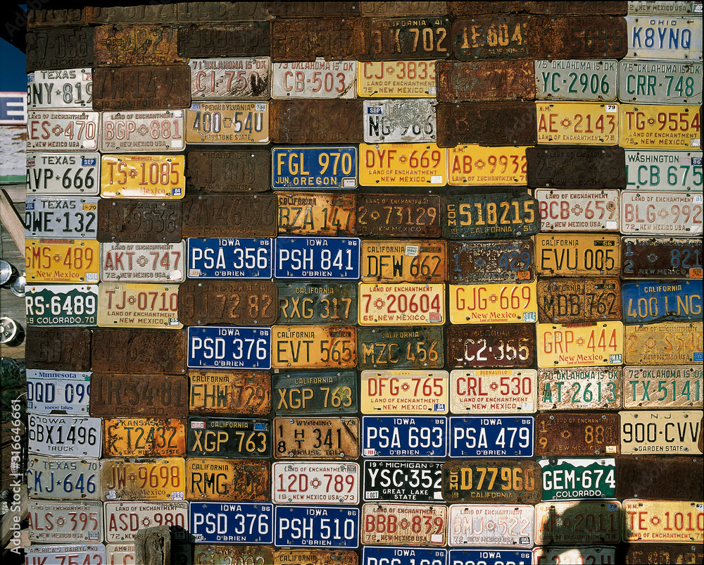 This is a wall of old license plates. It is a piece of roadside ...