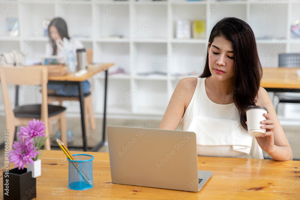 Beautiful asian woman using laptop at cafe while drinking coffee ...