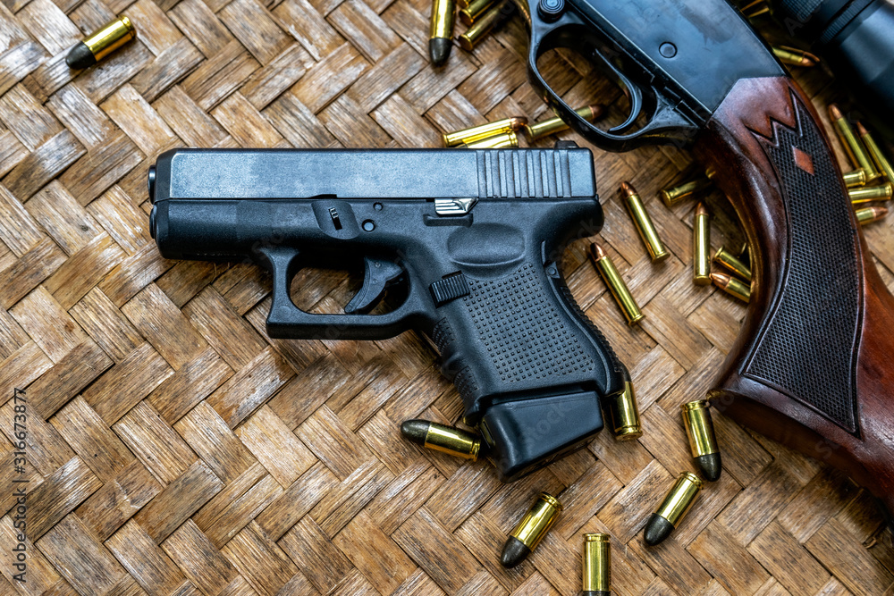 Guns and ammunition placed in a wooden table,Short guns and ammunition ...