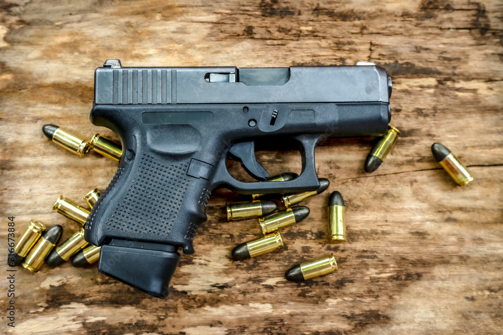 Guns and ammunition placed in a wooden table,Short guns and ammunition ...