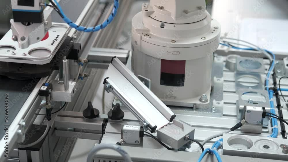 Close-up of robot arm pick product from automated car and place to ...