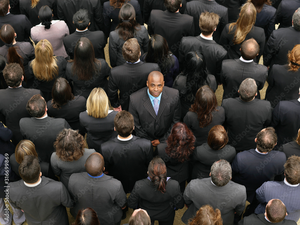 Black businessman looking at the camera standing in the middle of a ...