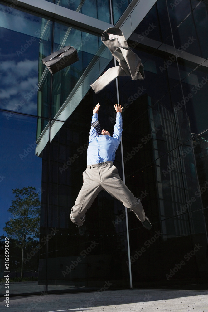 Joyful business man throwing his suit jacket in the air after resigning ...