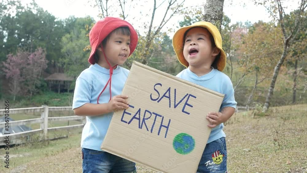 Two little child girl siblings holding "Save the planet" Poster showing ...
