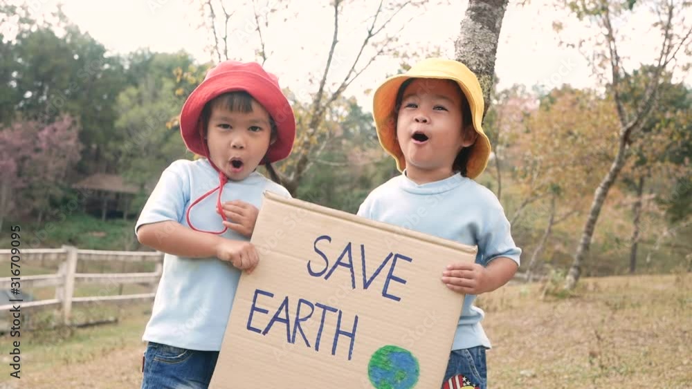 Two little child girl siblings holding "Save the planet" Poster showing ...