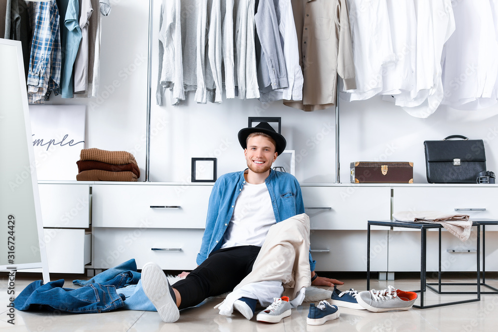 Handsome man choosing clothes in dressing room Stock Photo | Adobe Stock