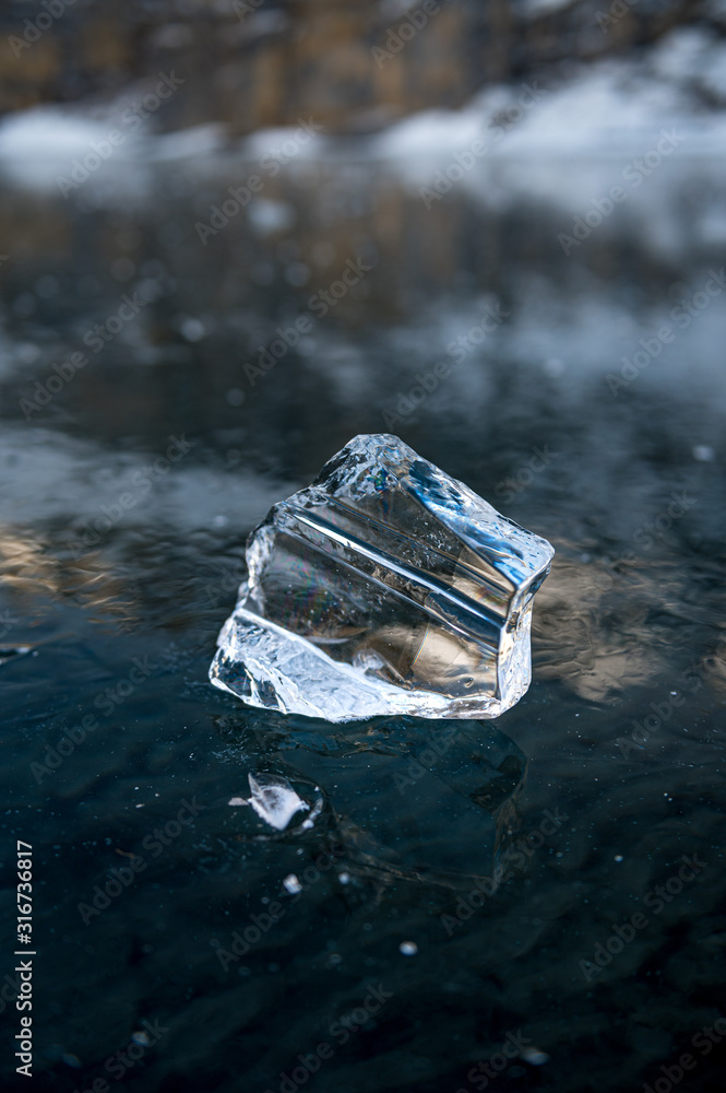 beautiful clear chunk of ice on frozen lake Oeschinensee with ...