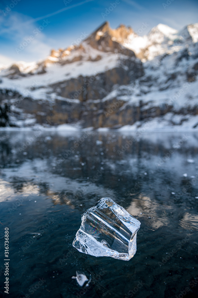 beautiful clear chunk of ice on frozen lake Oeschinensee with ...