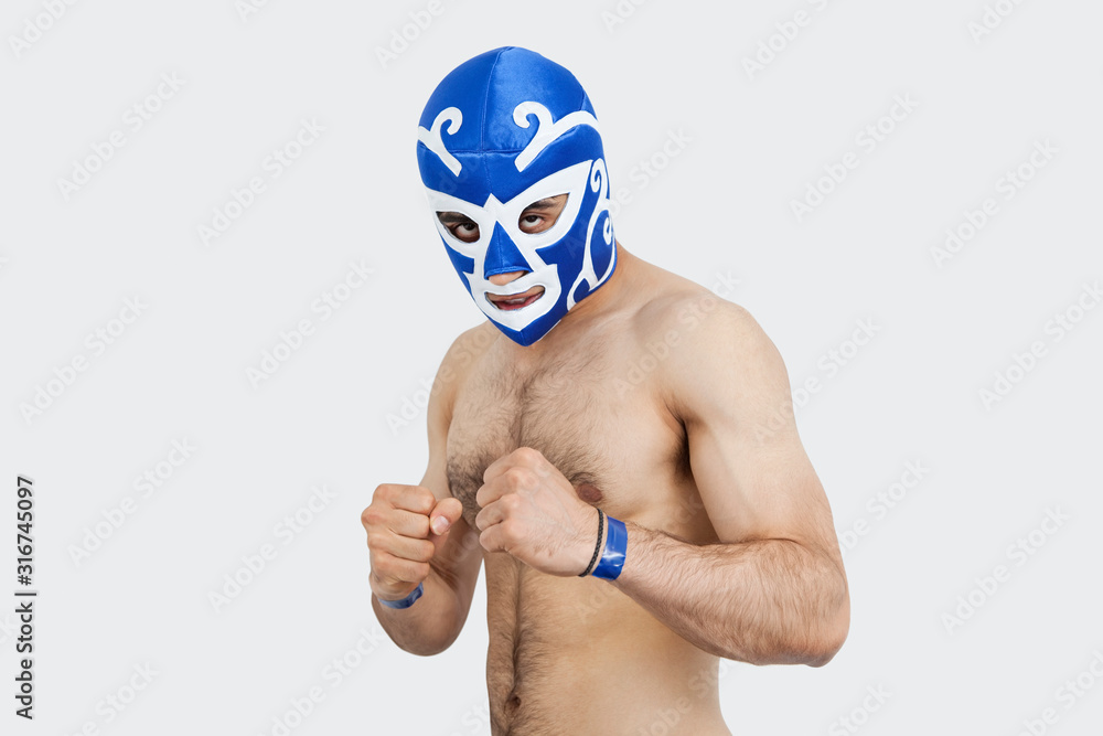 Portrait of a young shirtless male wrestler wearing wrestling mask over ...
