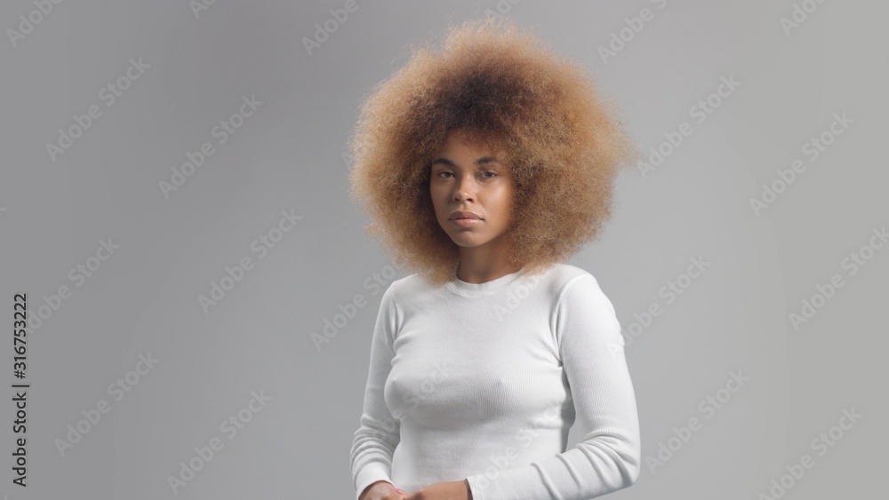 Foto de Mixed race black woman with big blonde afro hair in studio ...