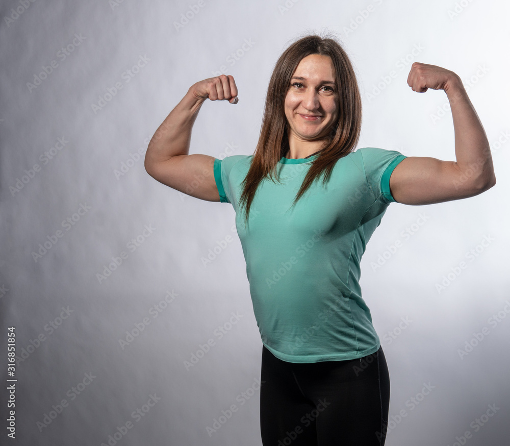 Fitness girl, female bodybuilder demonstrates biceps on white ...