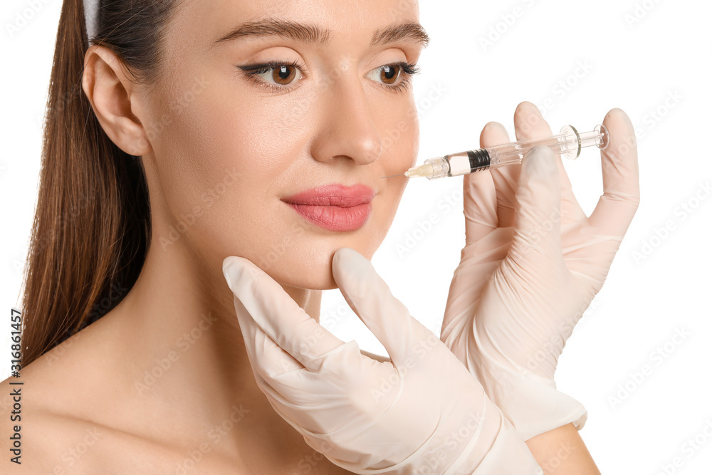 Young woman receiving filler injection against white background Stock ...