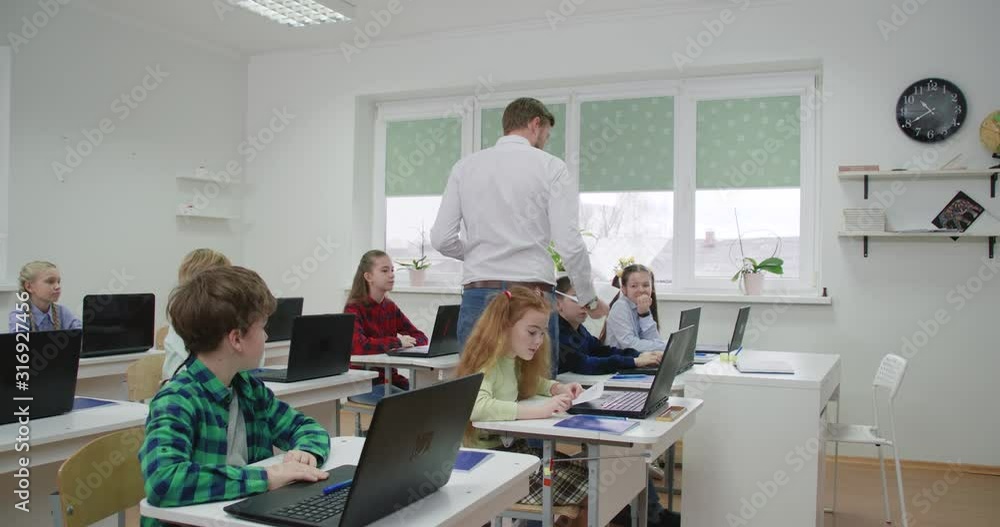 Education at modern school, the teacher gives students tests on sheets ...