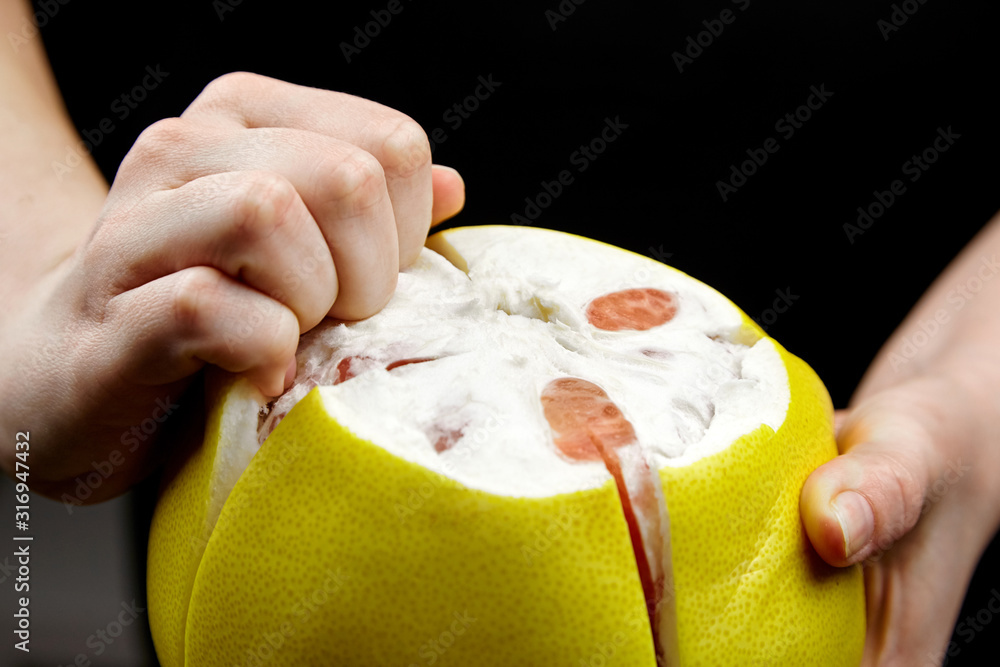 Pomelo citrus fruit with sweet red flesh and yellow thick rind on black ...