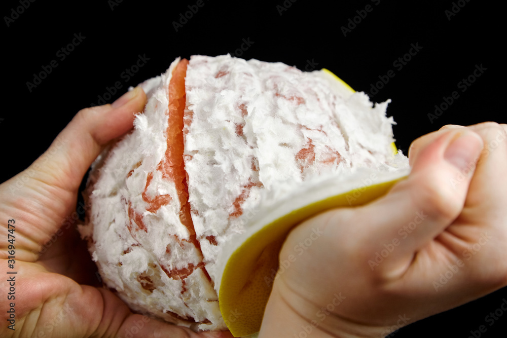 Pomelo citrus fruit with sweet red flesh and yellow thick rind on black ...