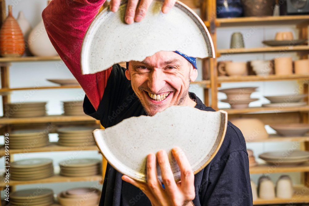 Crazy potter master smiling through the broken ceramic hand made plates ...