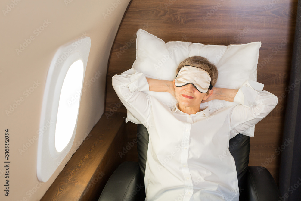 beautiful stylish woman aged sleeping in a private jet cabin on a ...