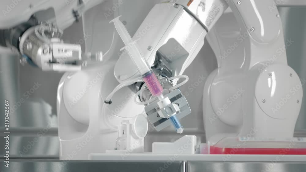Robotic arm makes an injection with chemotherapy medicine. Two ...
