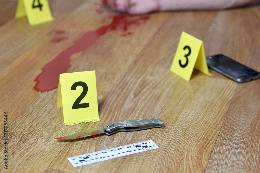 Crime scene investigation - Bloody knife and victims hand with yellow ...