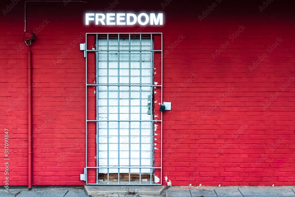 Red Wall with Door secured by Iron Gratings and the Word Freedom in ...