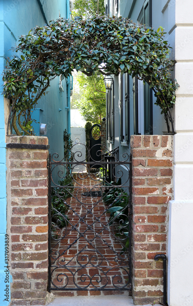 Visible from the street, a weathered wrought iron gate between ...