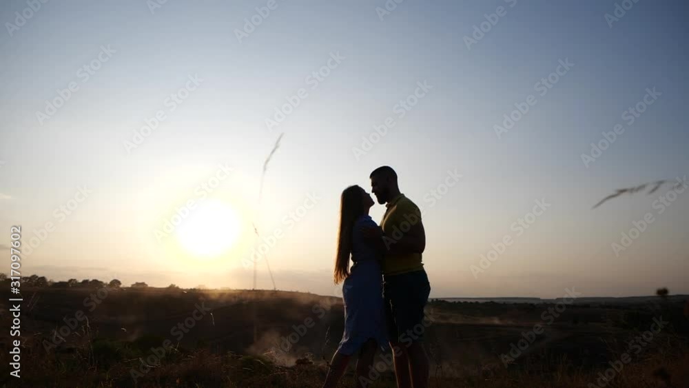 Young beautiful couple girl and boy are flirting in on the field at ...