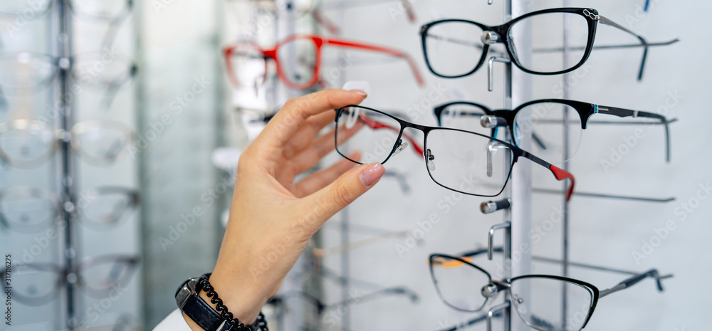 Row of glasses at an opticians. Eyeglasses shop. Stand with glasses in ...