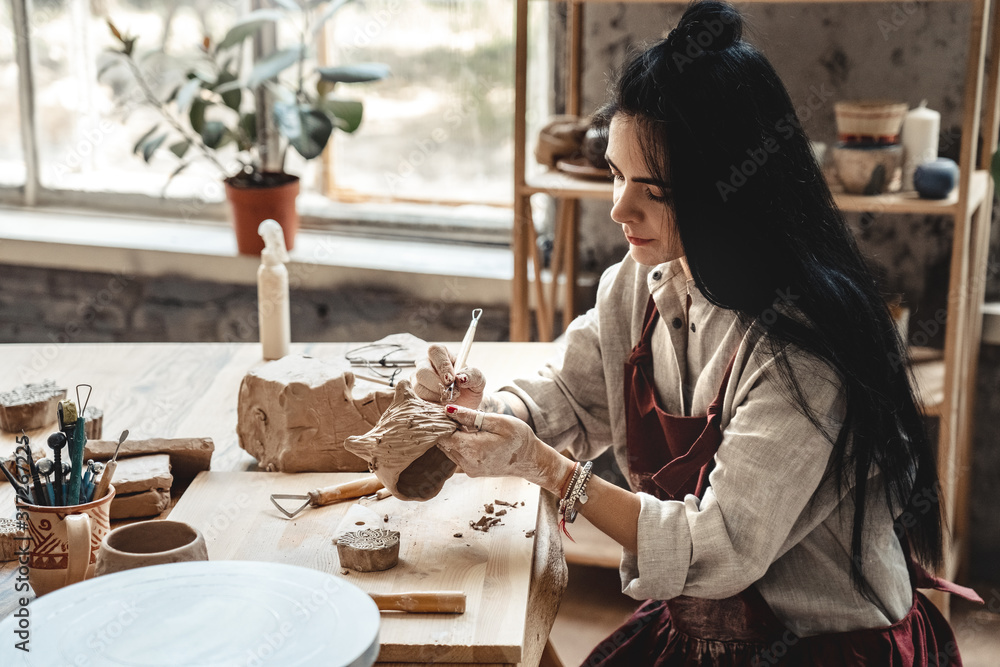 Craftsperson Concept. Young woman making pottery indoors making shape ...